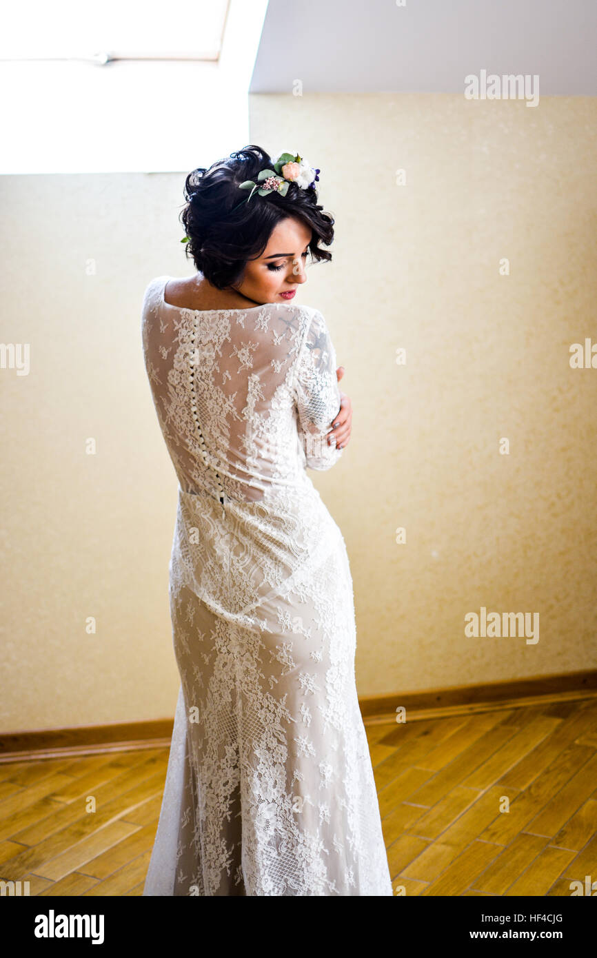 Beautiful bride in white lace dress and flowers in hair. Waiting in ...