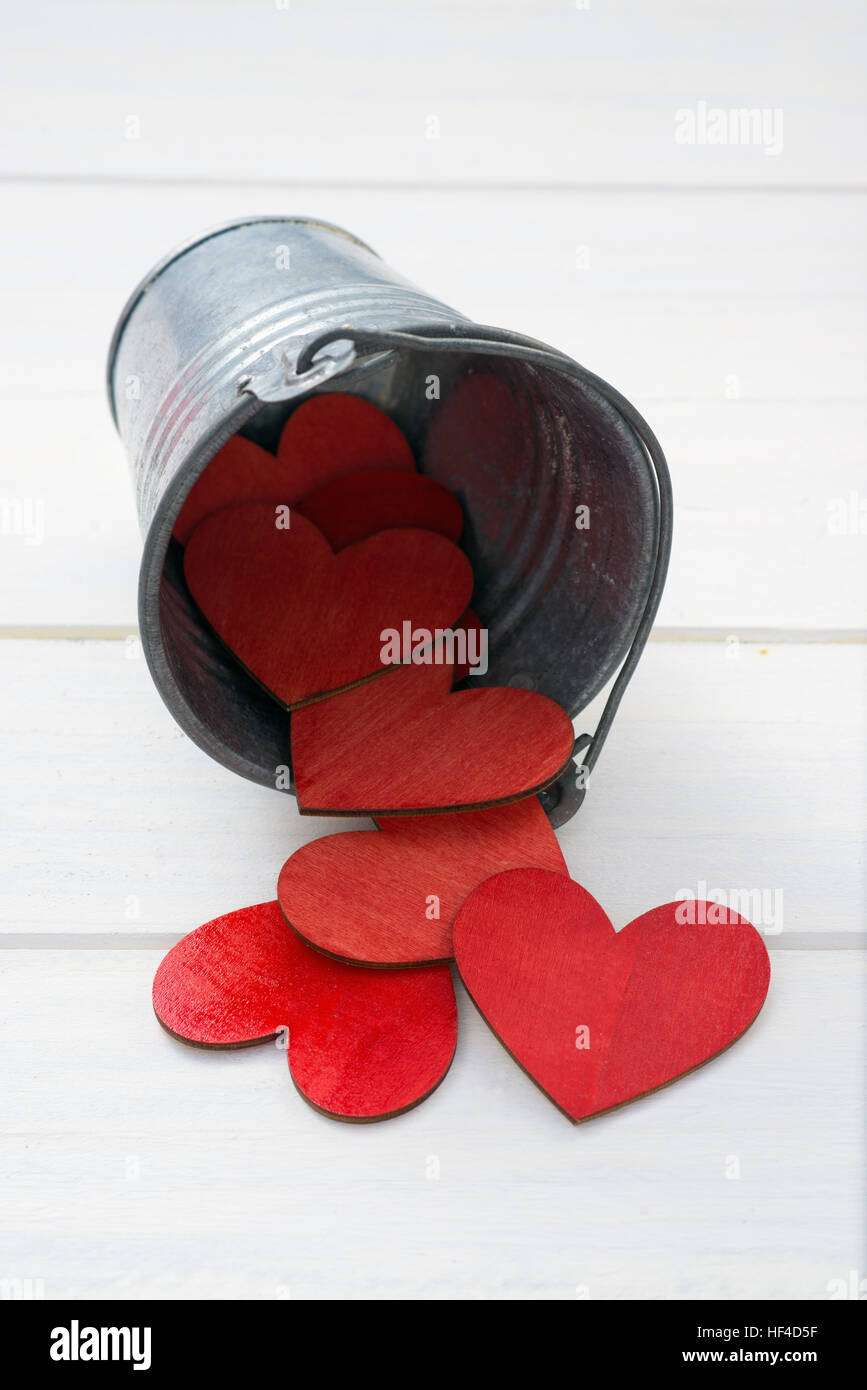 Metal bucket pouring red hearts Stock Photo - Alamy