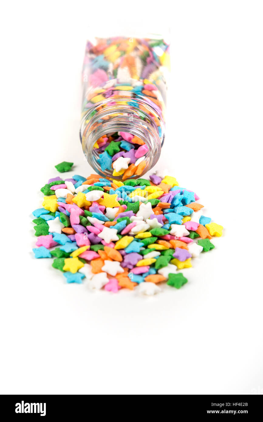 Assorted rainbow colored sprinkles and bottle isolated on white ...