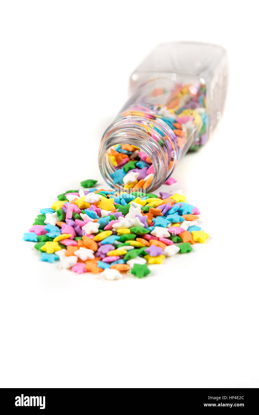 Assorted rainbow colored sprinkles and bottle isolated on white ...