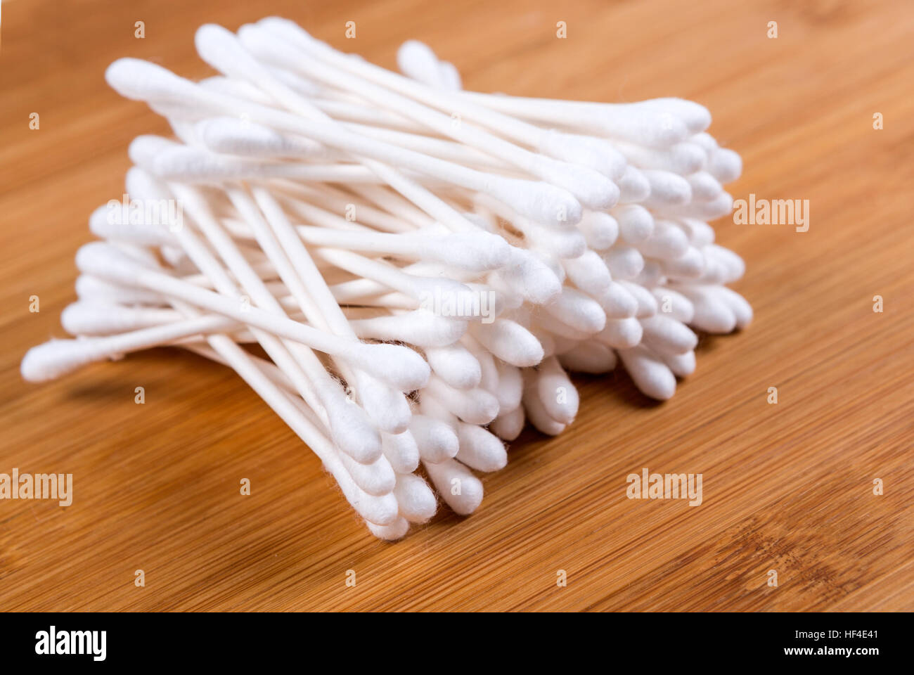 Pile of white cotton swabs isolated on wood background Stock Photo - Alamy