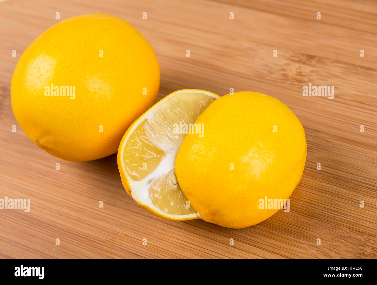 Two meyer lemons isolated on wood background Stock Photo - Alamy