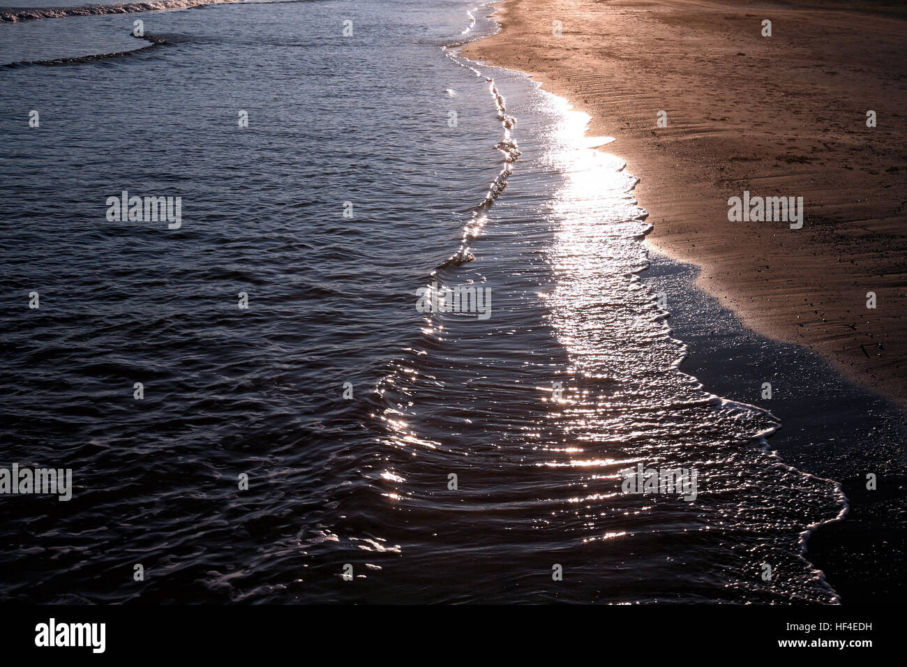 beach with sand and reflection of sun in the water Stock Photo - Alamy