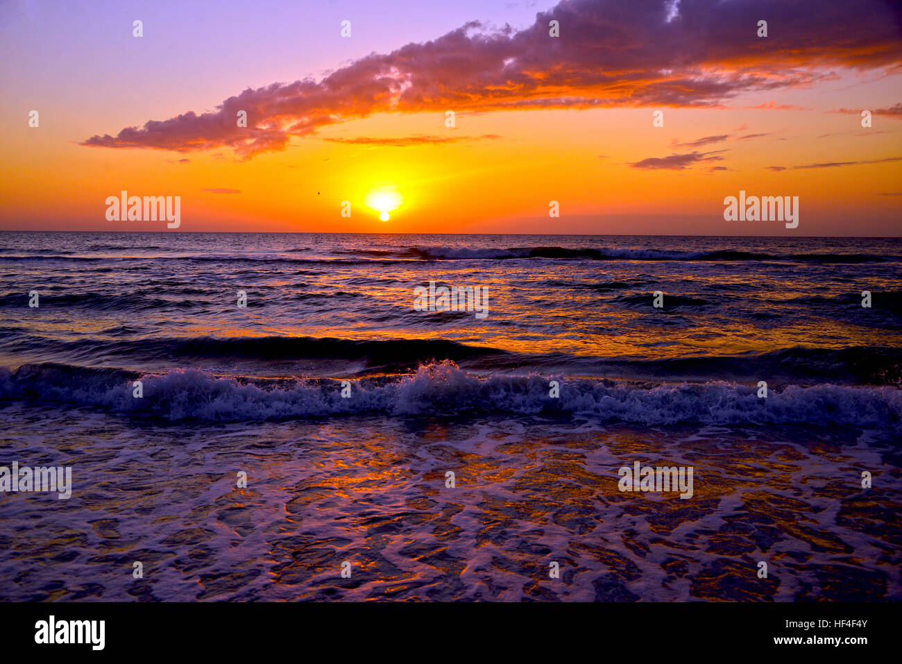 Waves at the beach, sunset Stock Photo - Alamy