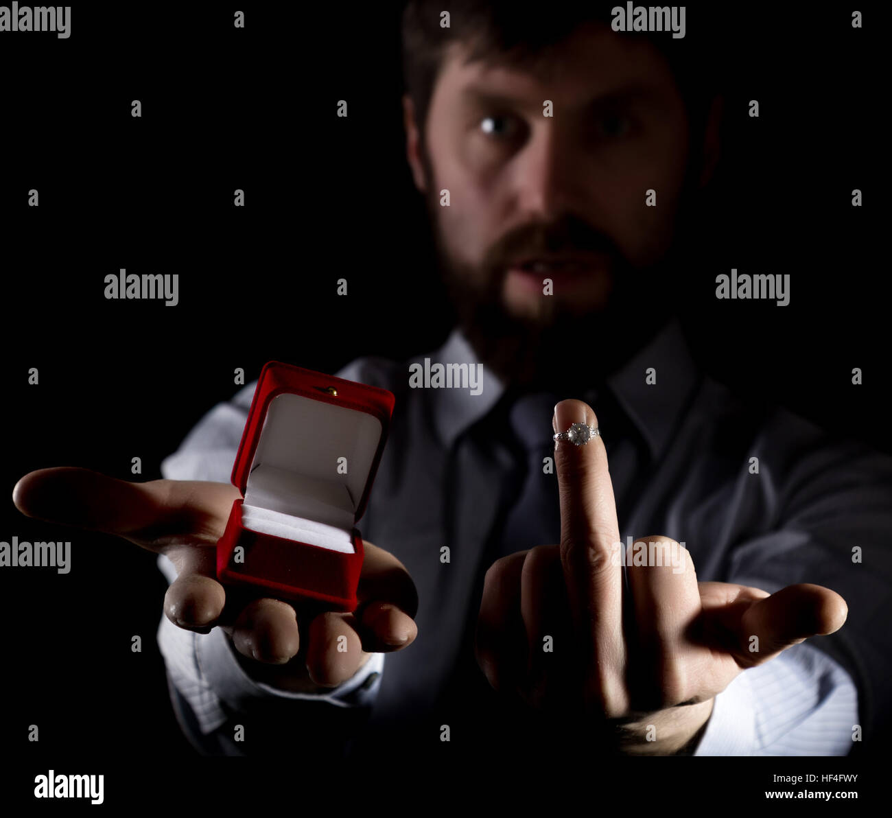 bearded man in business suit gives a ring in the red box and showing ...