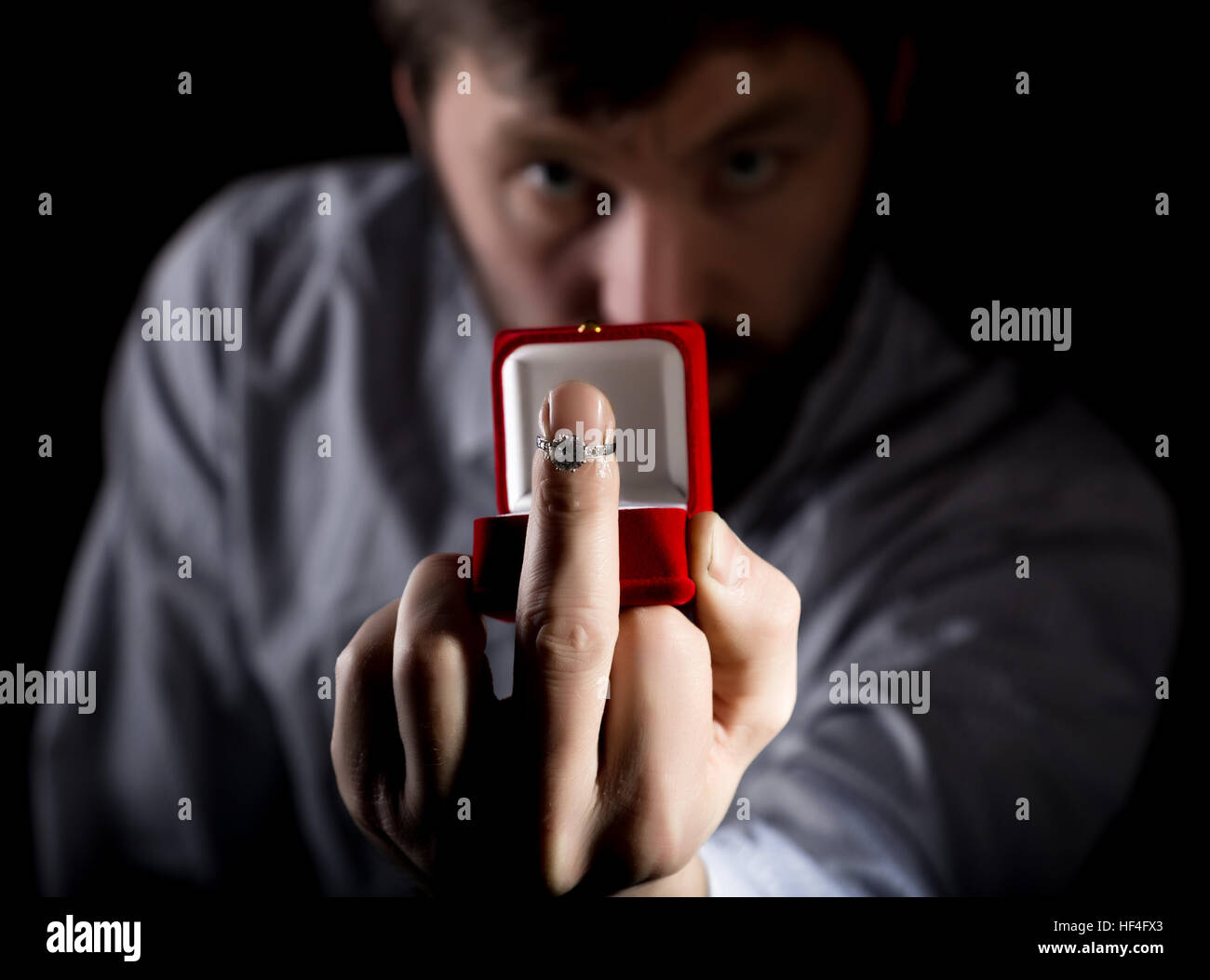 bearded man in business suit gives a ring in the red box and showing ...