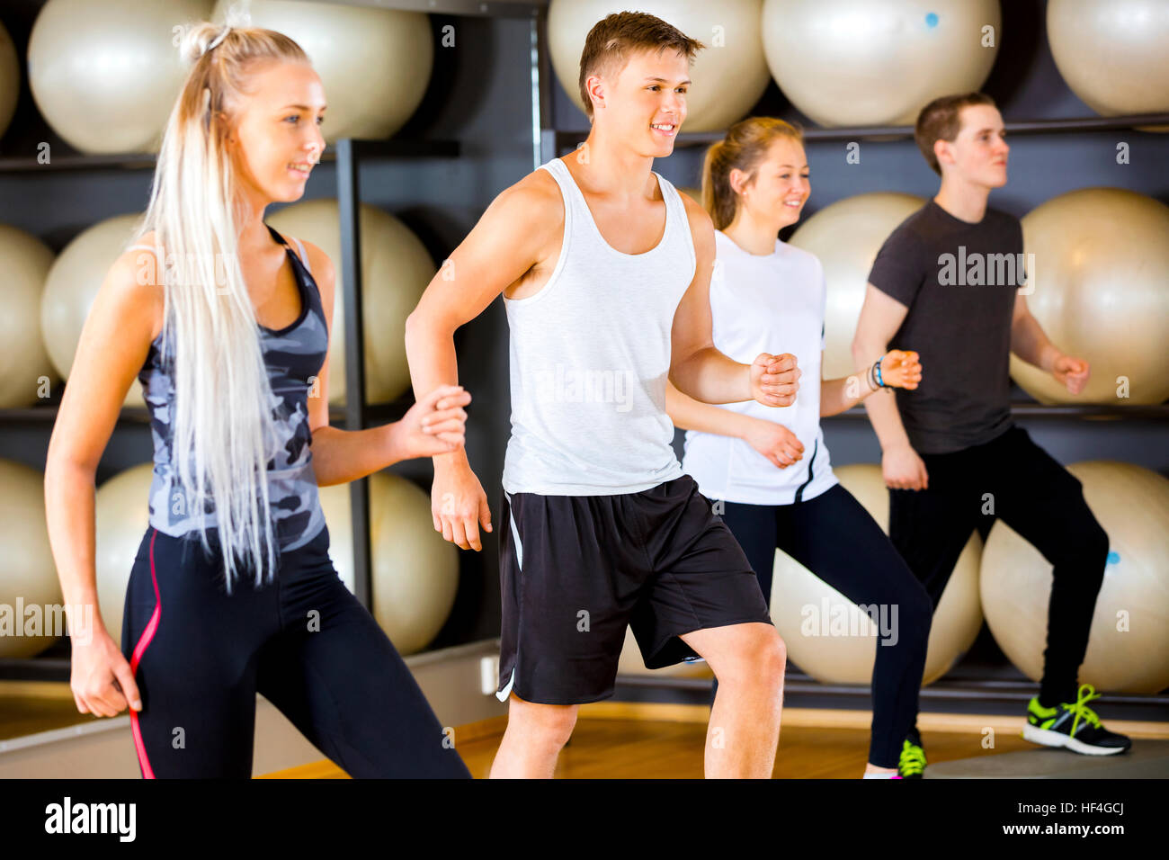Motivated workout group jumps at platforms in a fitness gym Stock Photo ...