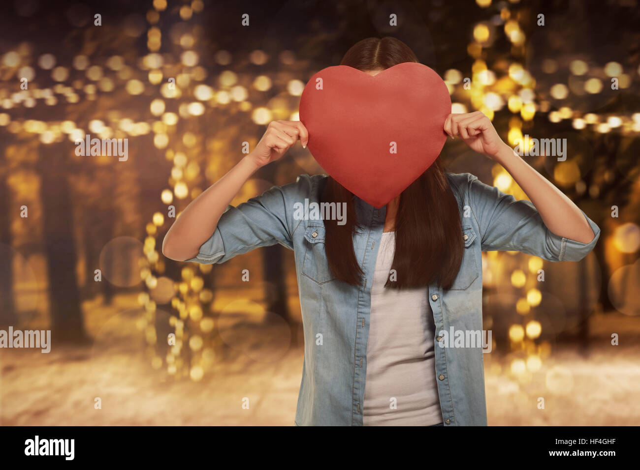 Young asian woman covering her face with red heart shape against ...