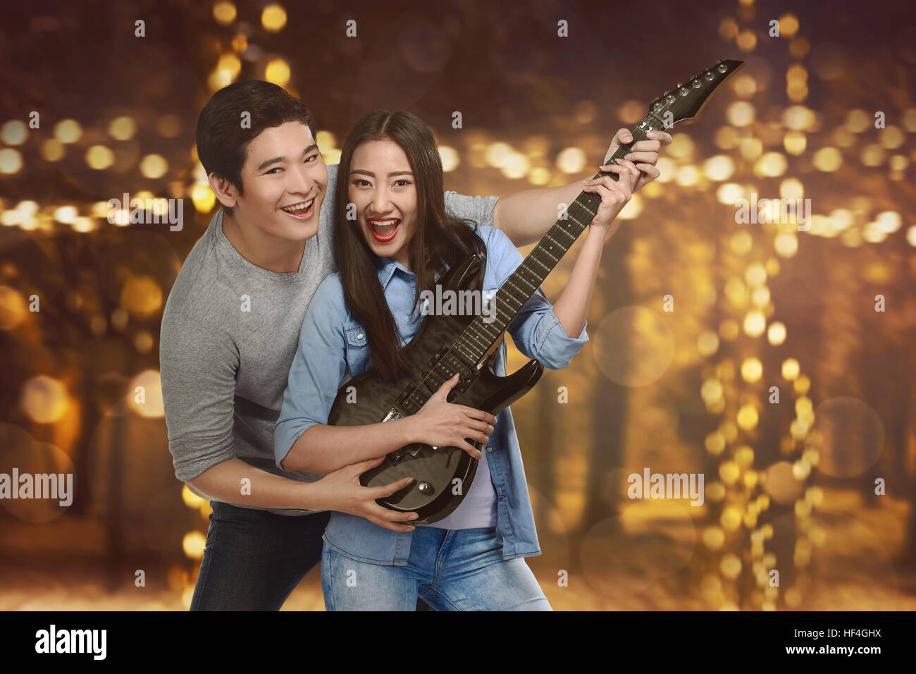 Romantic asian couple of lovers playing guitar in outdoor Stock Photo ...