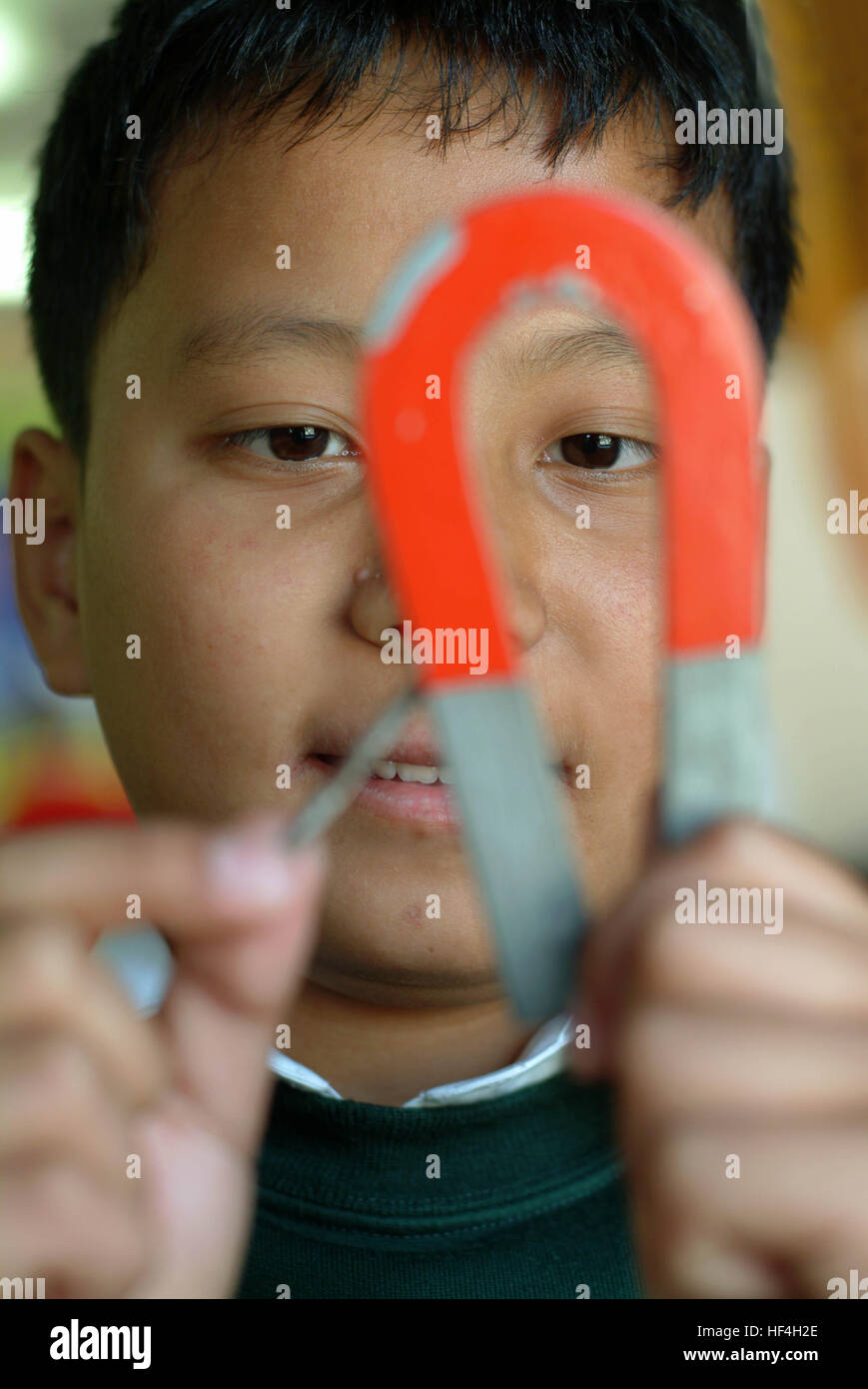 Students in a science class exploring magnetism with magnets and metal ...