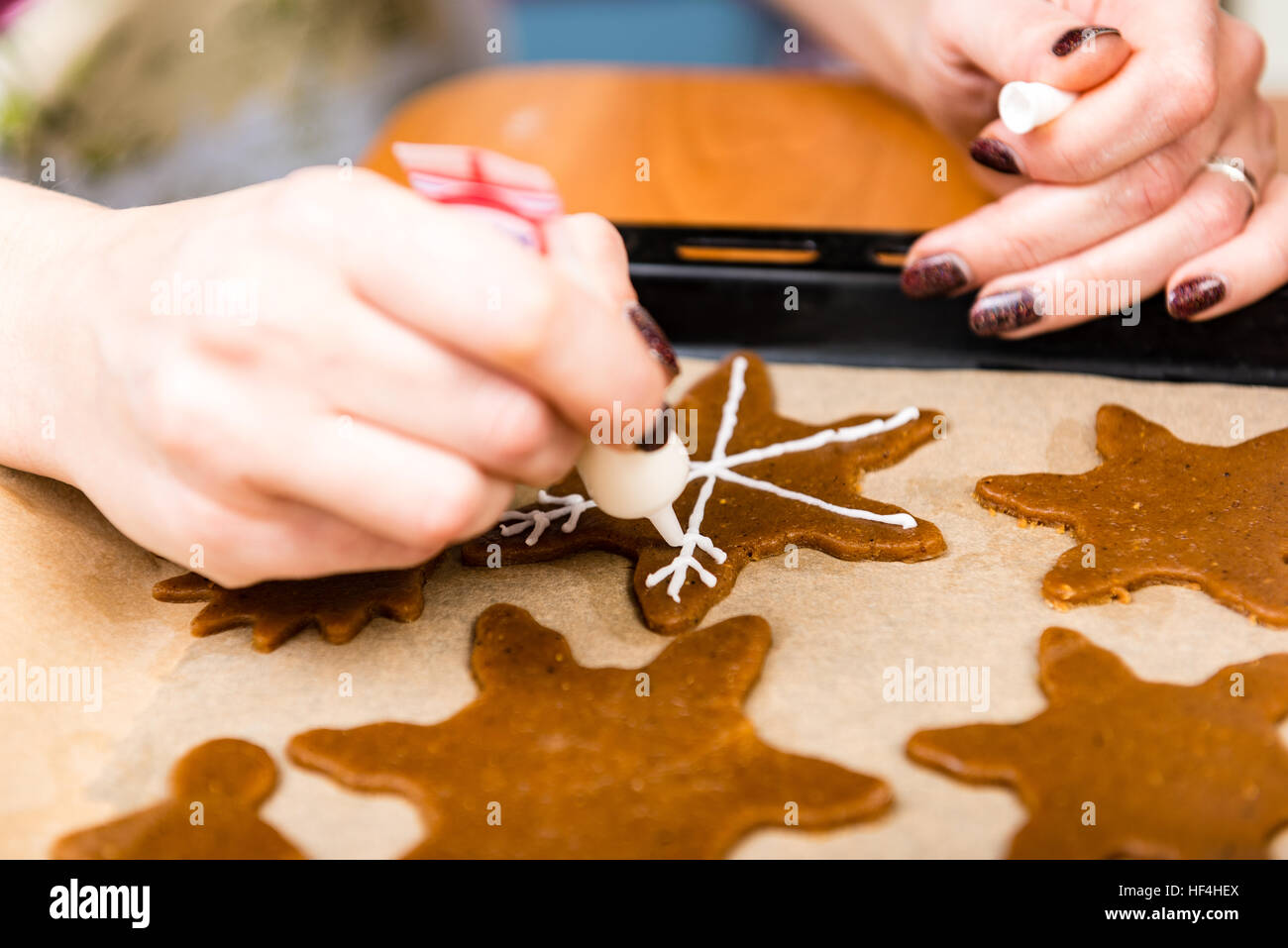 Womans hand decorating cookies with sugar. Making Gingerbread Cookies ...