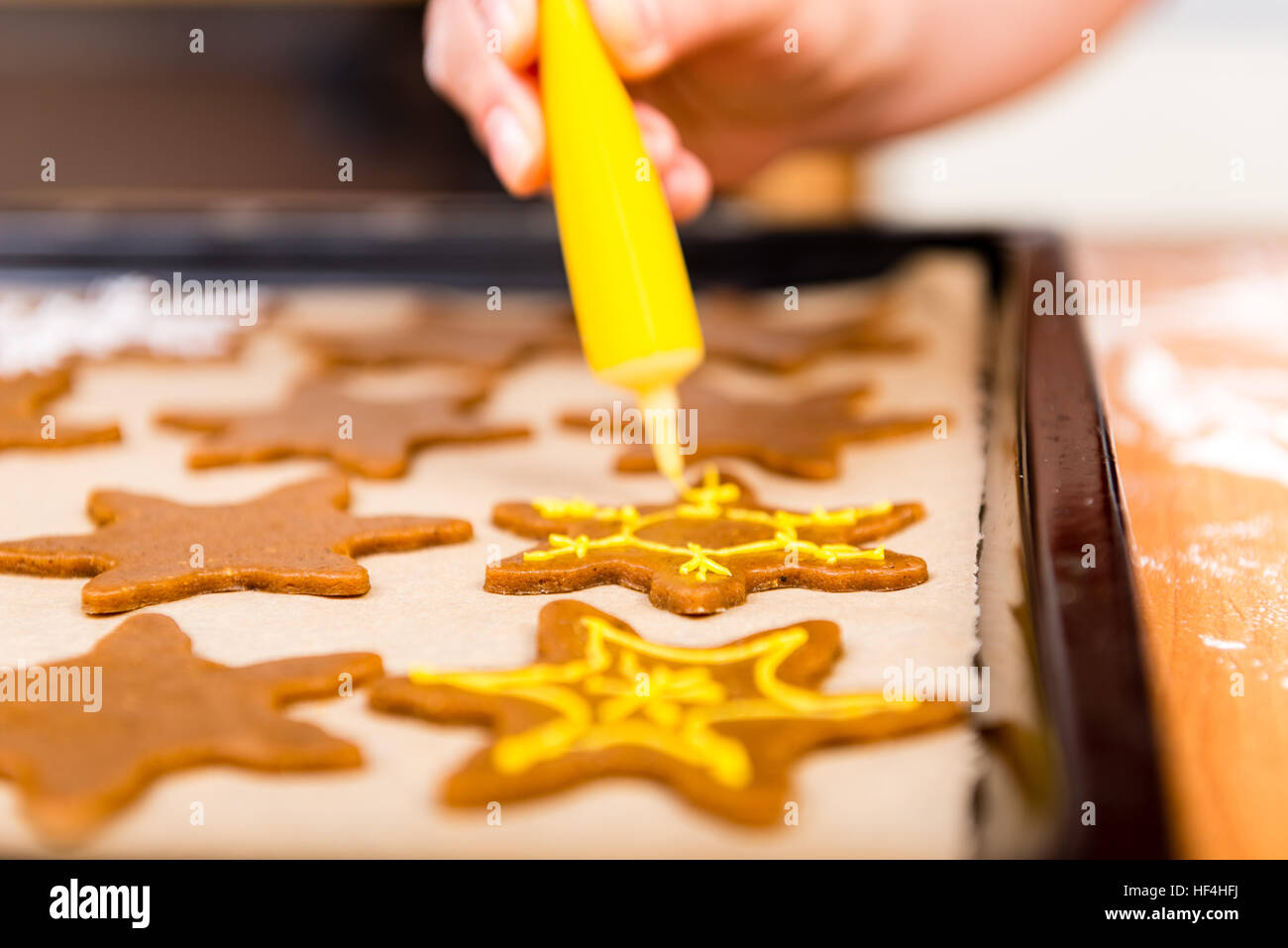 Womans hand decorating cookies with sugar. Making Gingerbread Cookies ...