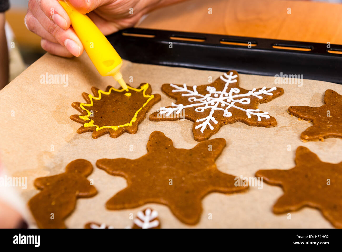 Womans hand decorating cookies with sugar. Making Gingerbread Cookies ...