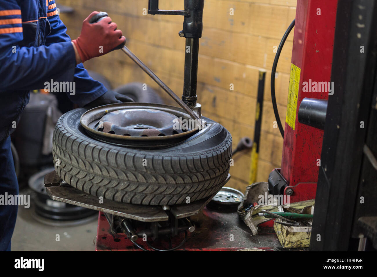 Professional auto mechanic replacing tire on wheel in car repair ...