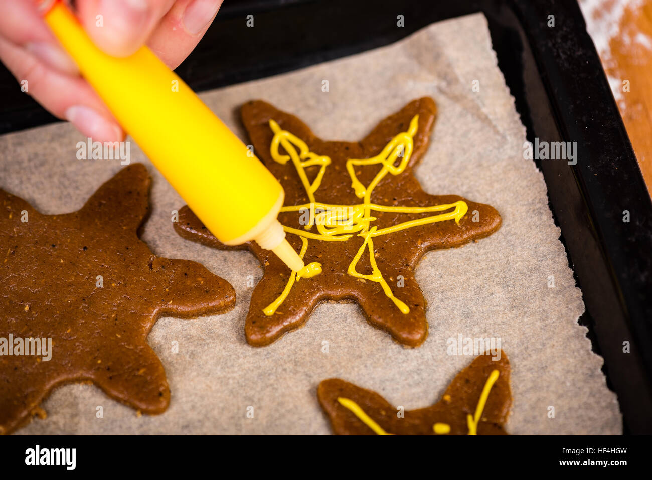 Womans hand decorating cookies with sugar. Making Gingerbread Cookies ...