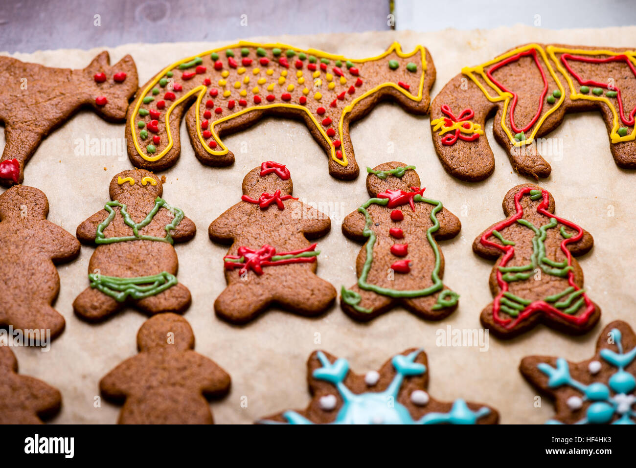 Womans hand decorating cookies with sugar. Making Gingerbread Cookies ...