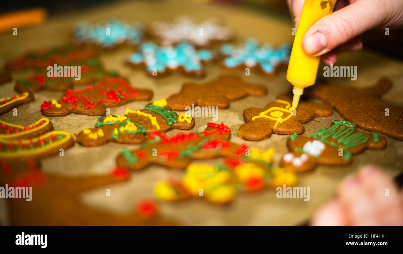 Womans hand decorating cookies with sugar. Making Gingerbread Cookies ...