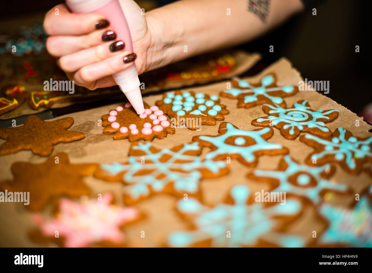 Womans hand decorating cookies with sugar. Making Gingerbread Cookies ...