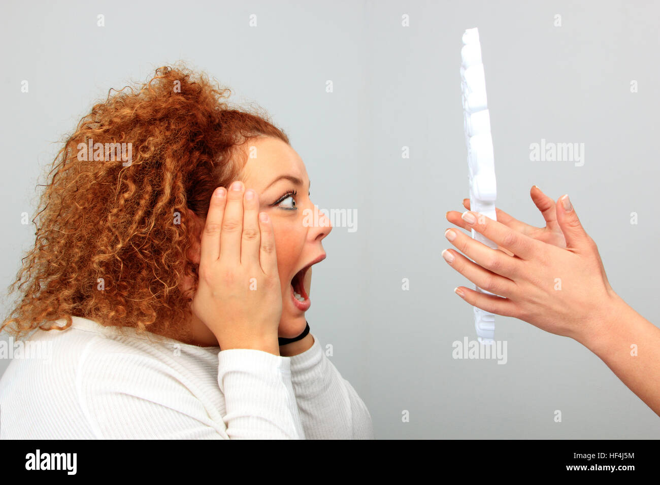 freaked girl looking at a small mirror Stock Photo - Alamy