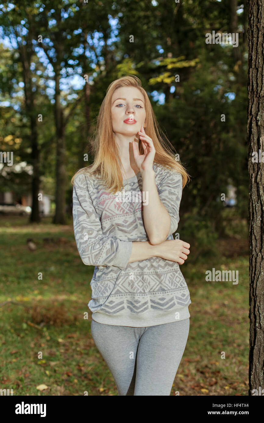 Beautiful elegant woman standing in a park in autumn Stock Photo - Alamy