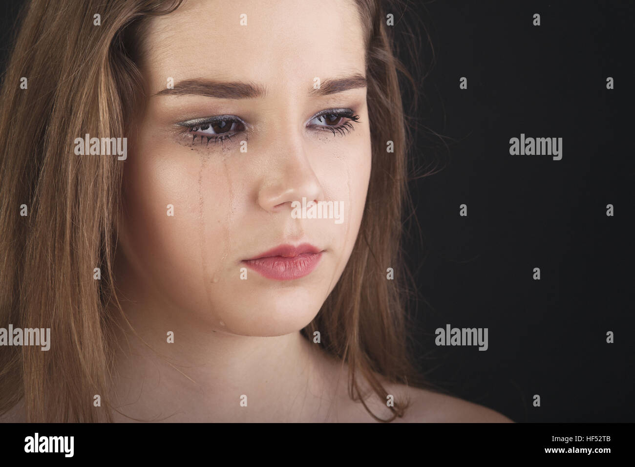 sad young woman crying on black background Stock Photo - Alamy