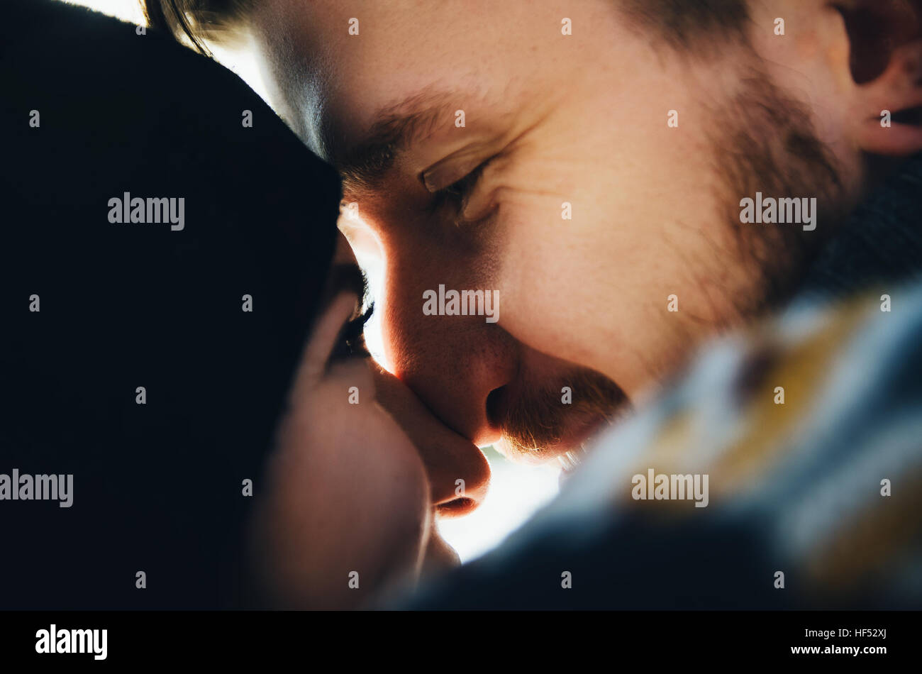 Happy girl in a hat kissing and touches noses boyfriend with a red ...