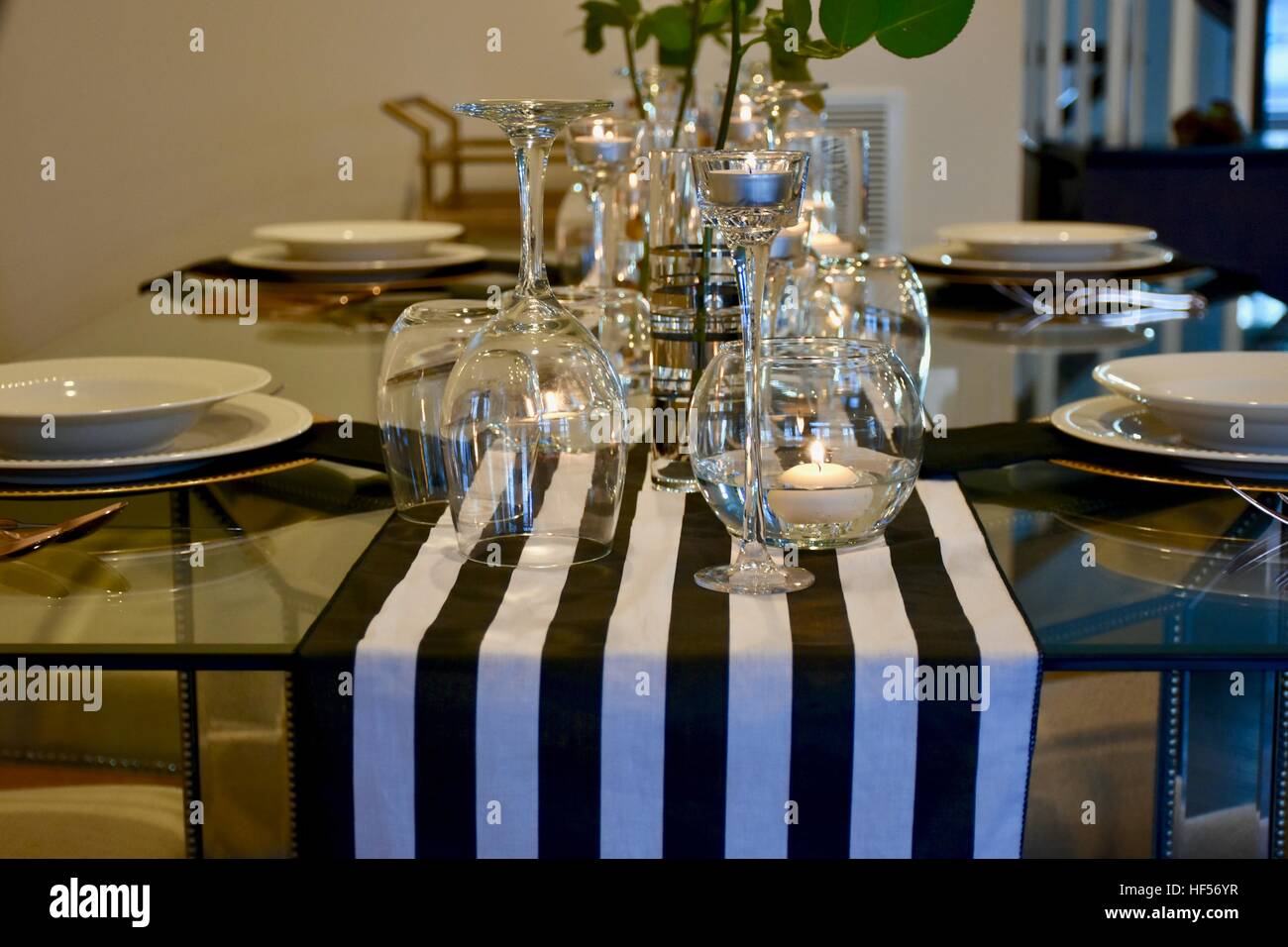 An elegant dinner set up prepared on a beautiful glass table for a ...