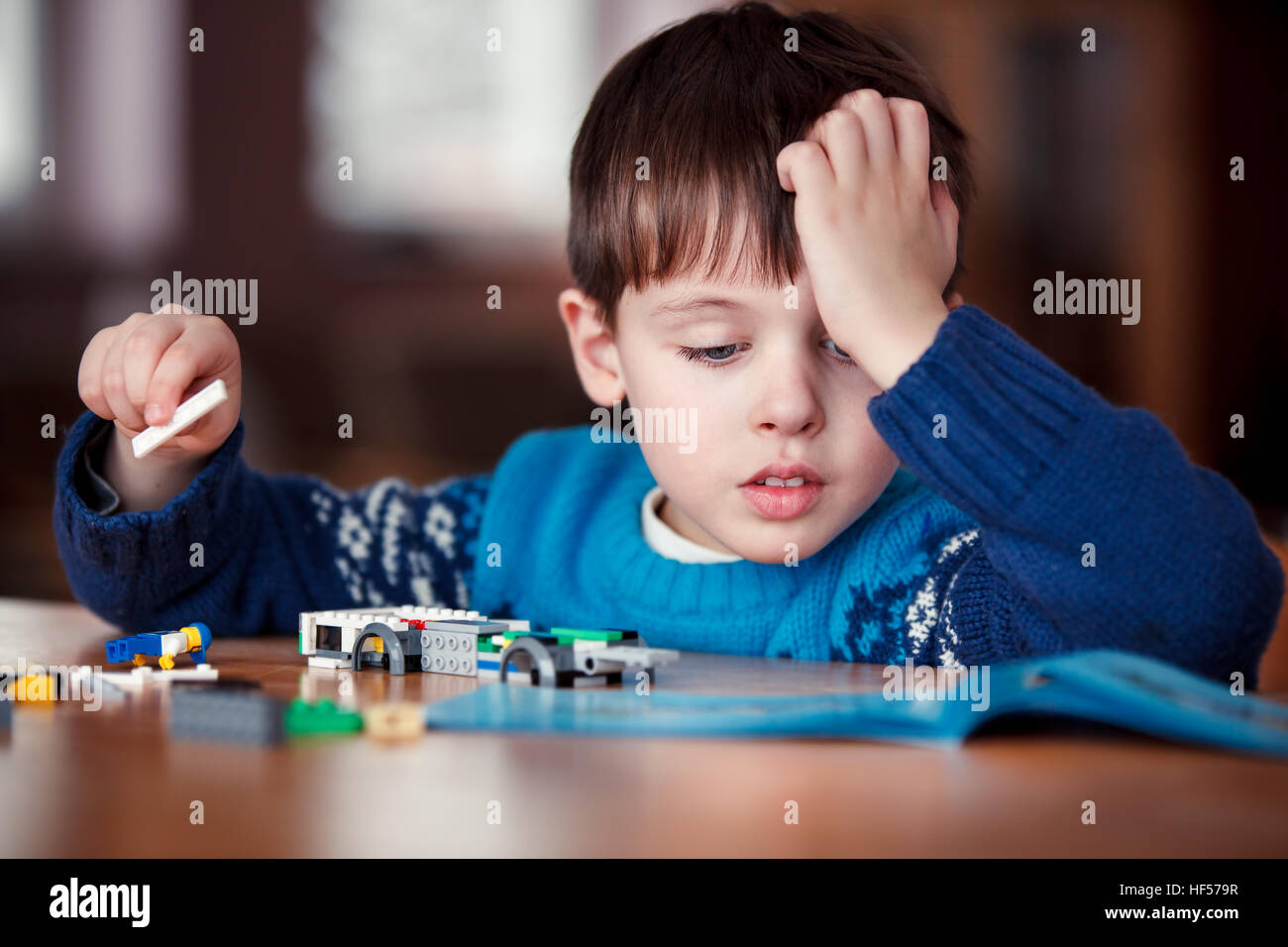Concentrated child reading a manual Stock Photo - Alamy