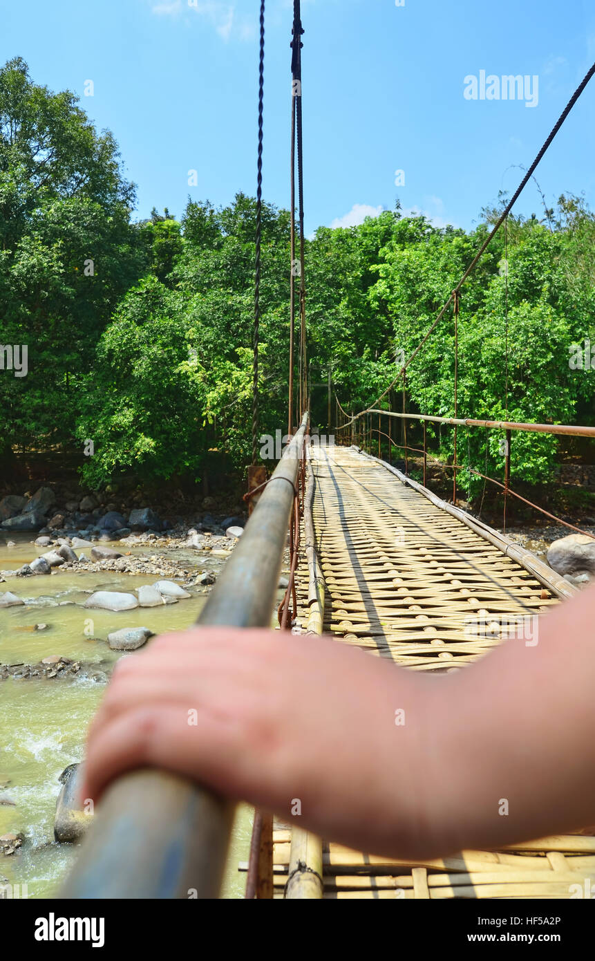 Hand holding iron rail of a wooden suspension bridge Stock Photo - Alamy