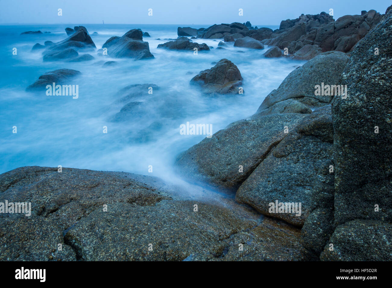 A long exposure of waves washing over rocks Stock Photo - Alamy