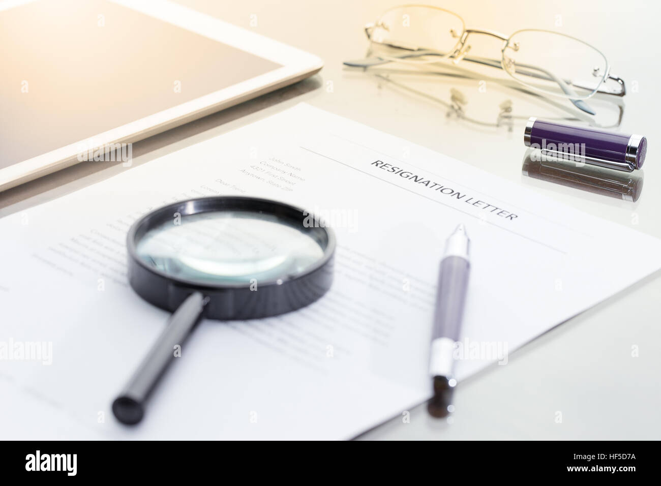 Businessman signing his resignation letter on his desk before sending ...