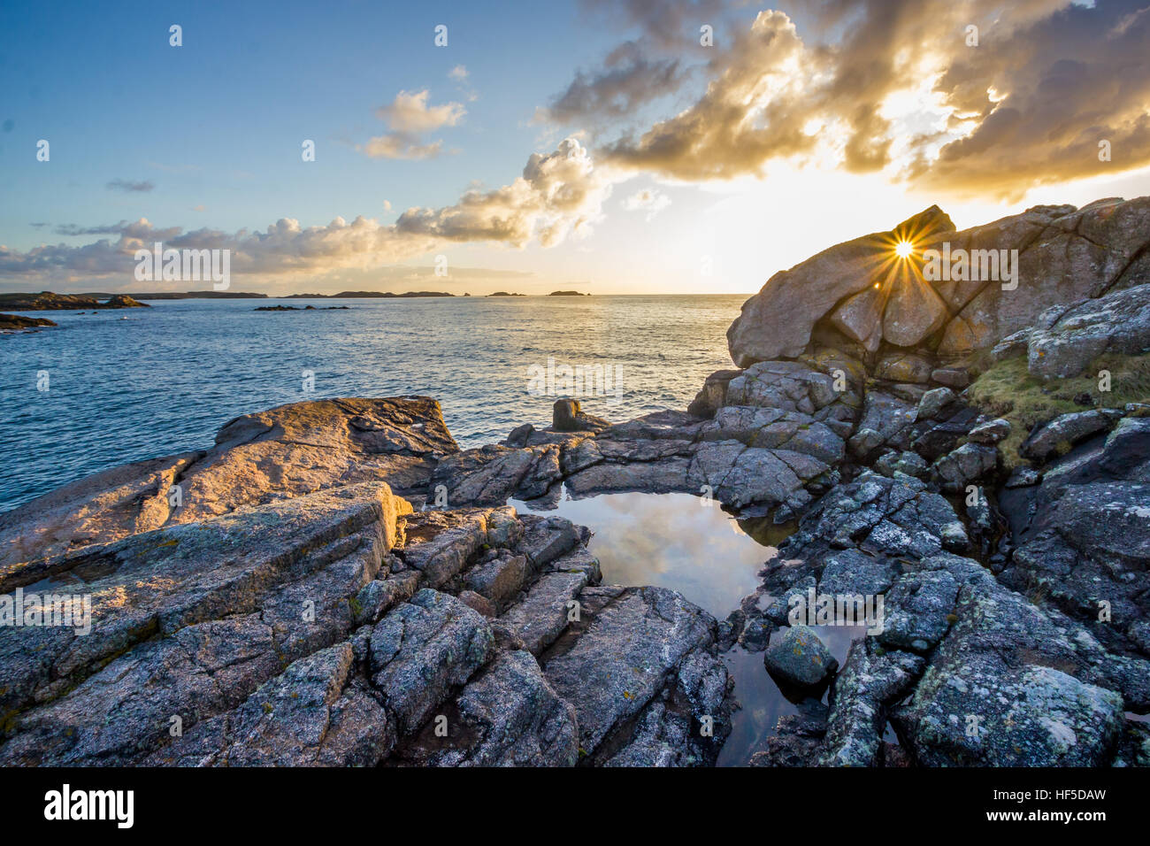Sunrise reflected in a rock pool with islands in the background Stock ...