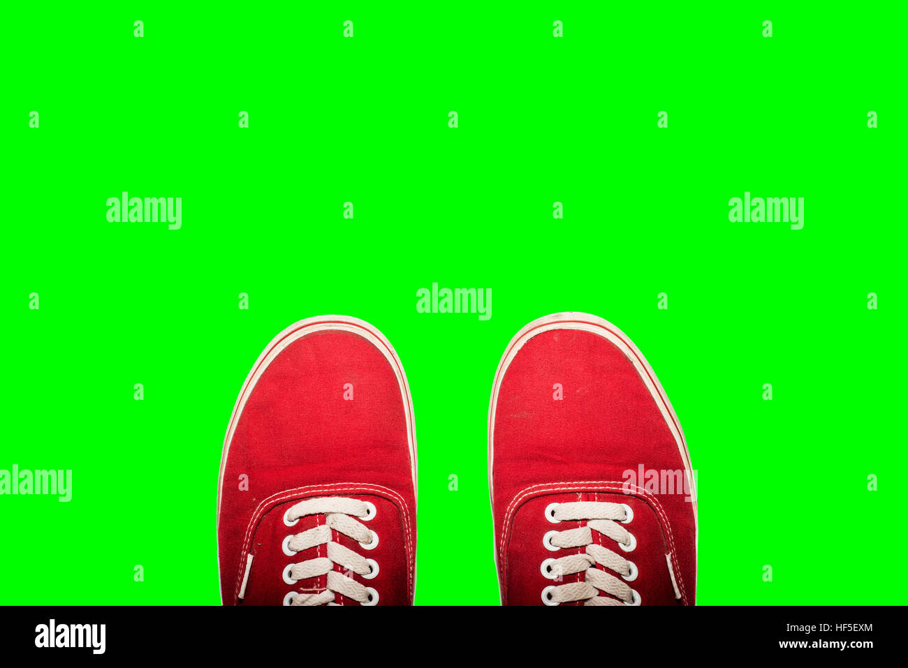 Pair of red shoes on bright green background Stock Photo - Alamy
