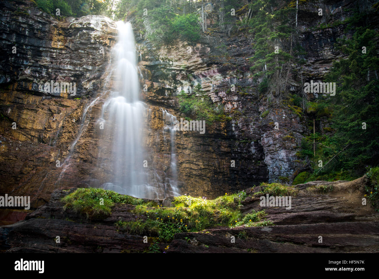 Waterfall flowing into a lush valley Stock Photo - Alamy