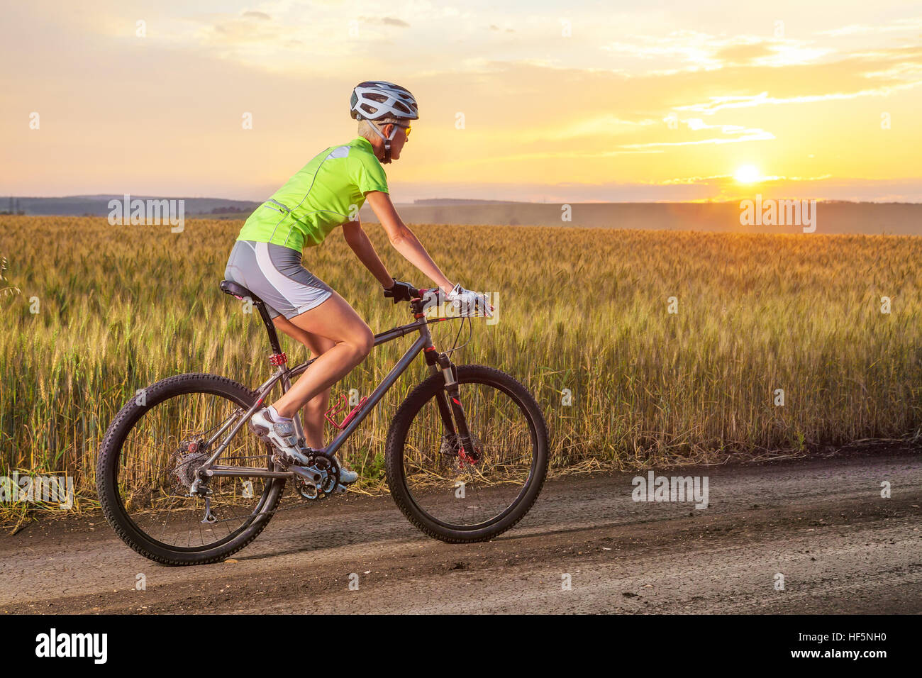 Biker riding rural road against sunset Stock Photo - Alamy