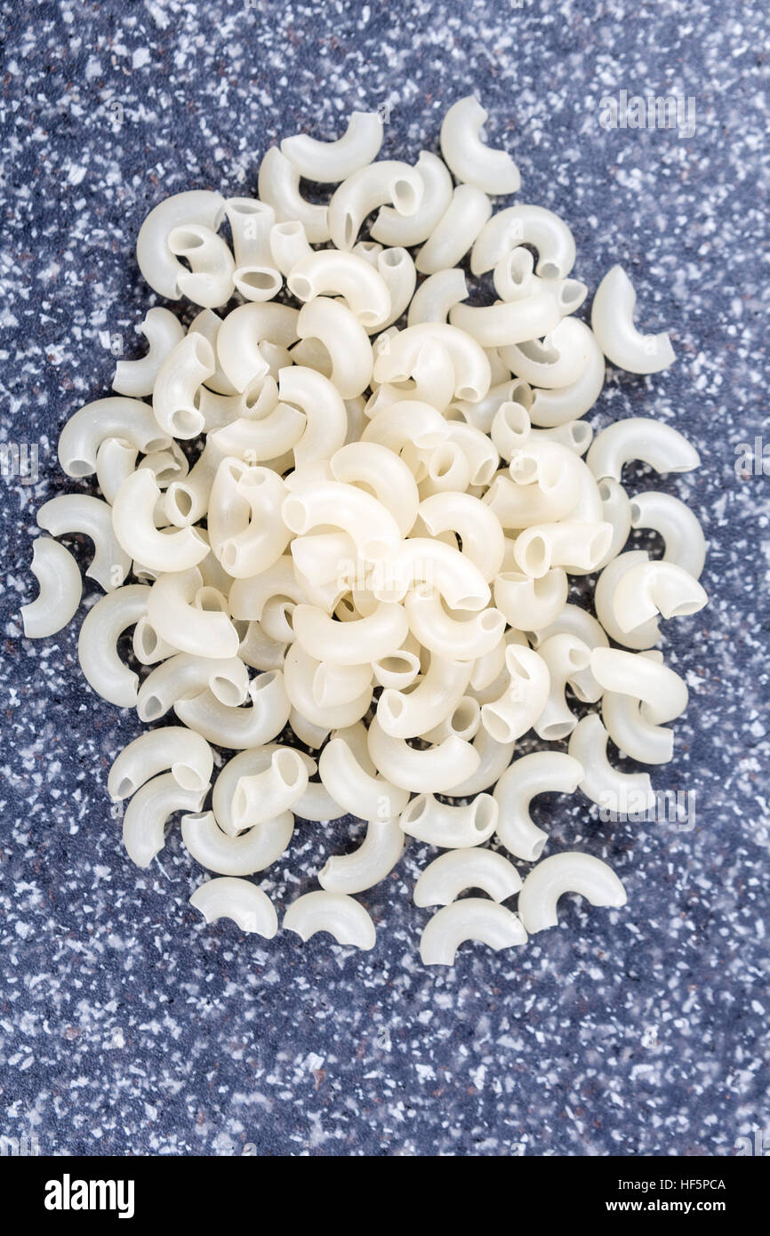 White rice elbow macaroni on a mottled grey blue background Stock Photo ...