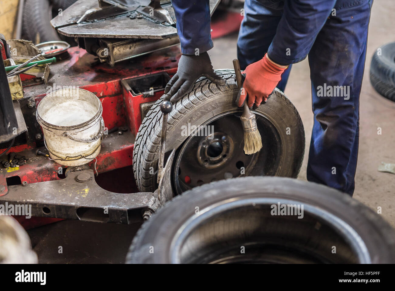 Professional auto mechanic replacing tire on wheel in car repair ...