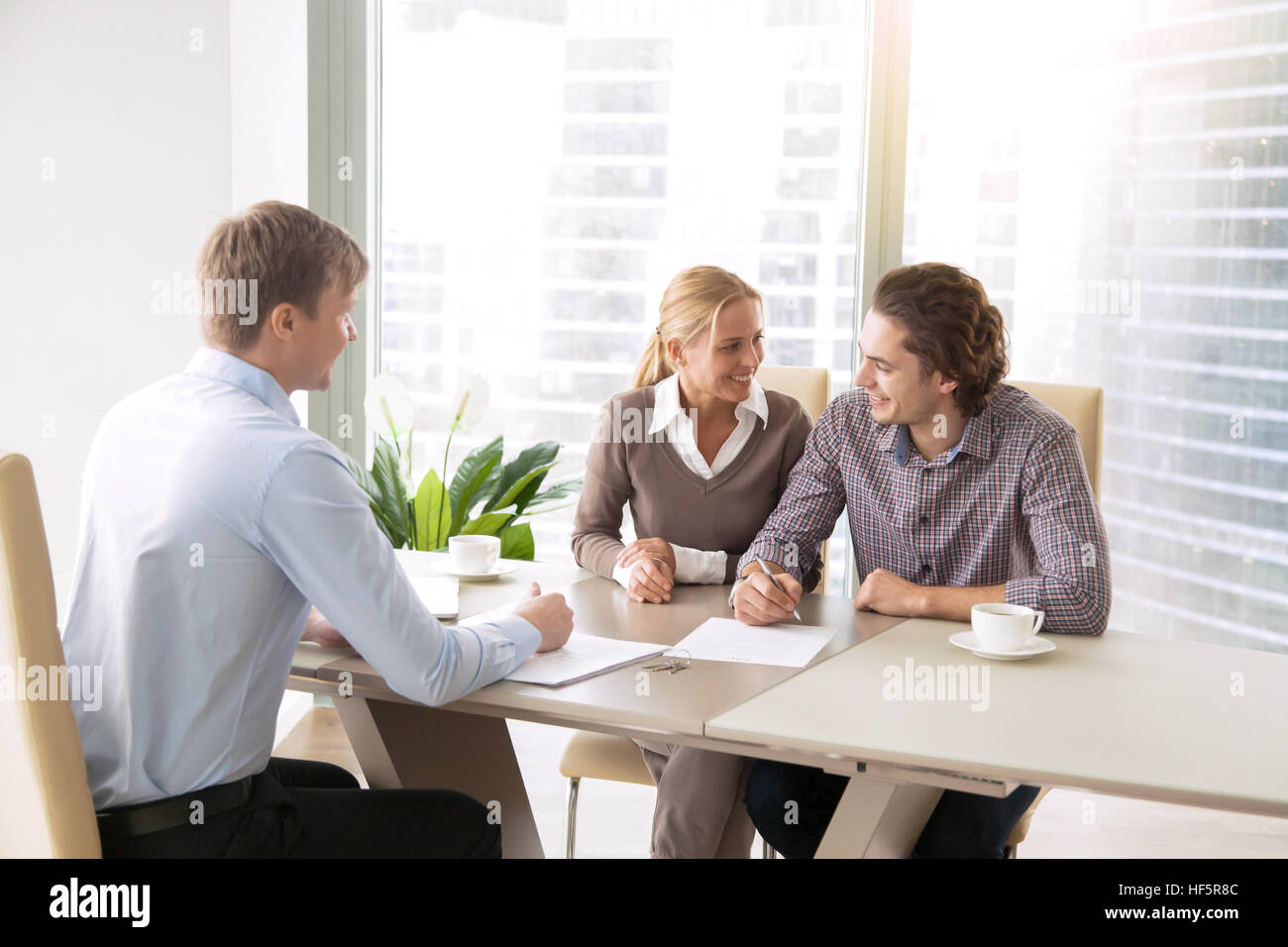 Young couple having a talk with agent Stock Photo - Alamy