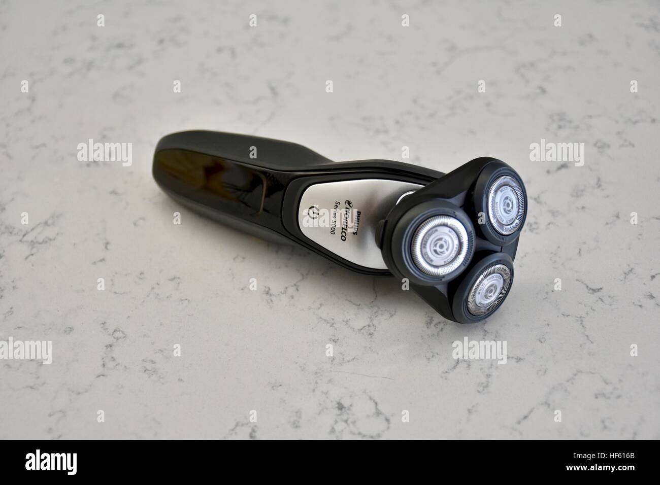 A Phillips Electric razor displayed on a white marble surface the ...