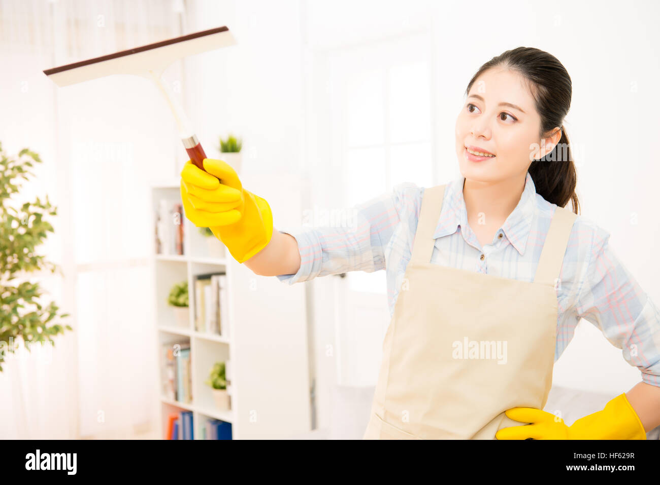 A portrait of a Beautiful young asian women doing domestic chores using ...