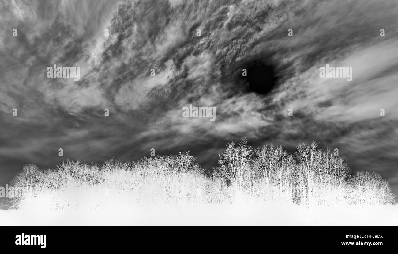 Stylized negative image of a landscape with clouds forming a massive ...