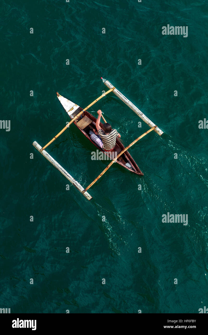 A Filipino man paddles his home-made pontoon outrigger canoe in Cebu ...