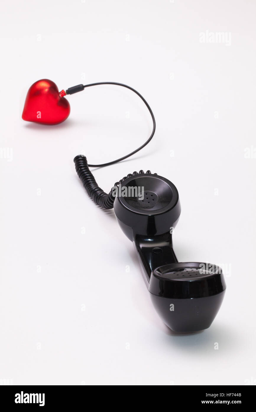 Old phone reciever and cord connection with red heart. Love hotline ...