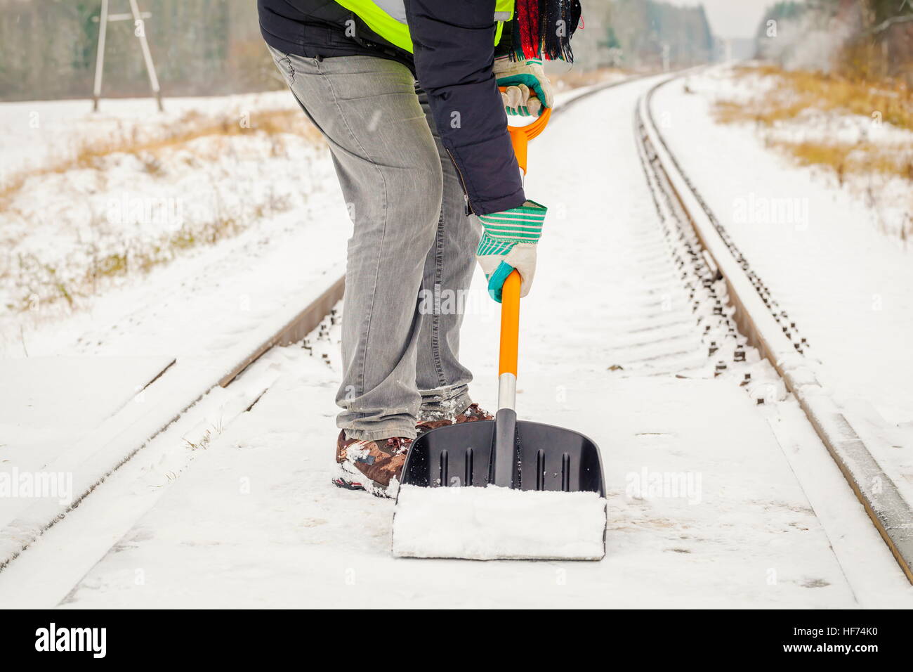 Railroad employee clean snow from the railway crossing Stock Photo - Alamy