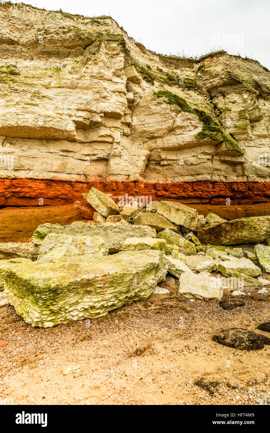 A large rockfall at the base of a dangerous cliff face showing ...