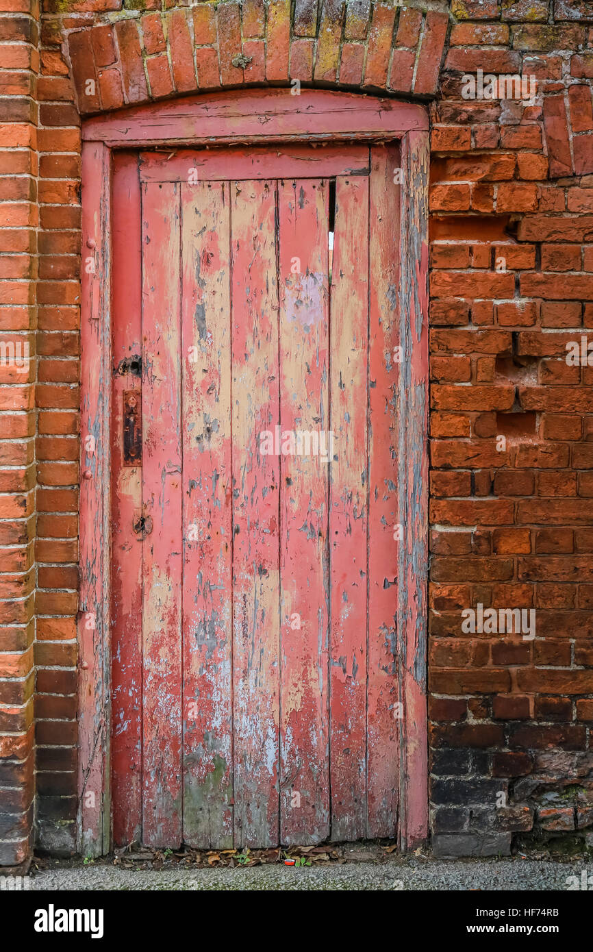 An old red door in a brick wall in need of repair Stock Photo - Alamy