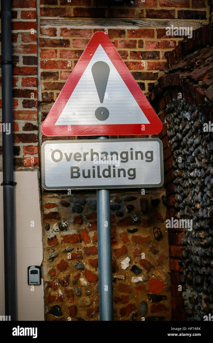 Unusual sign advising of an overhanging building Stock Photo - Alamy
