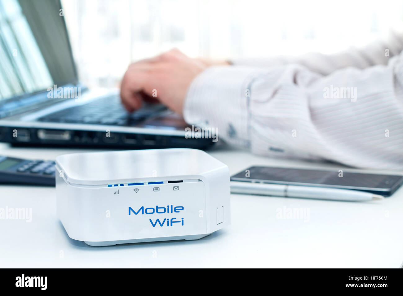 Mobile router device on the table and businessman with computer on ...
