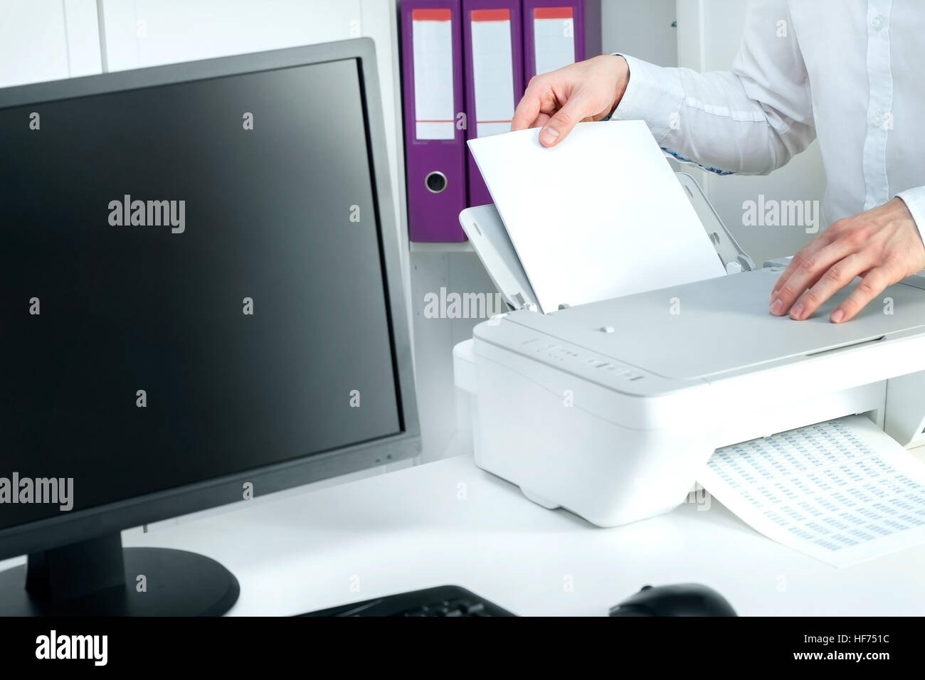 Man puts stack of paper into white printer Stock Photo - Alamy