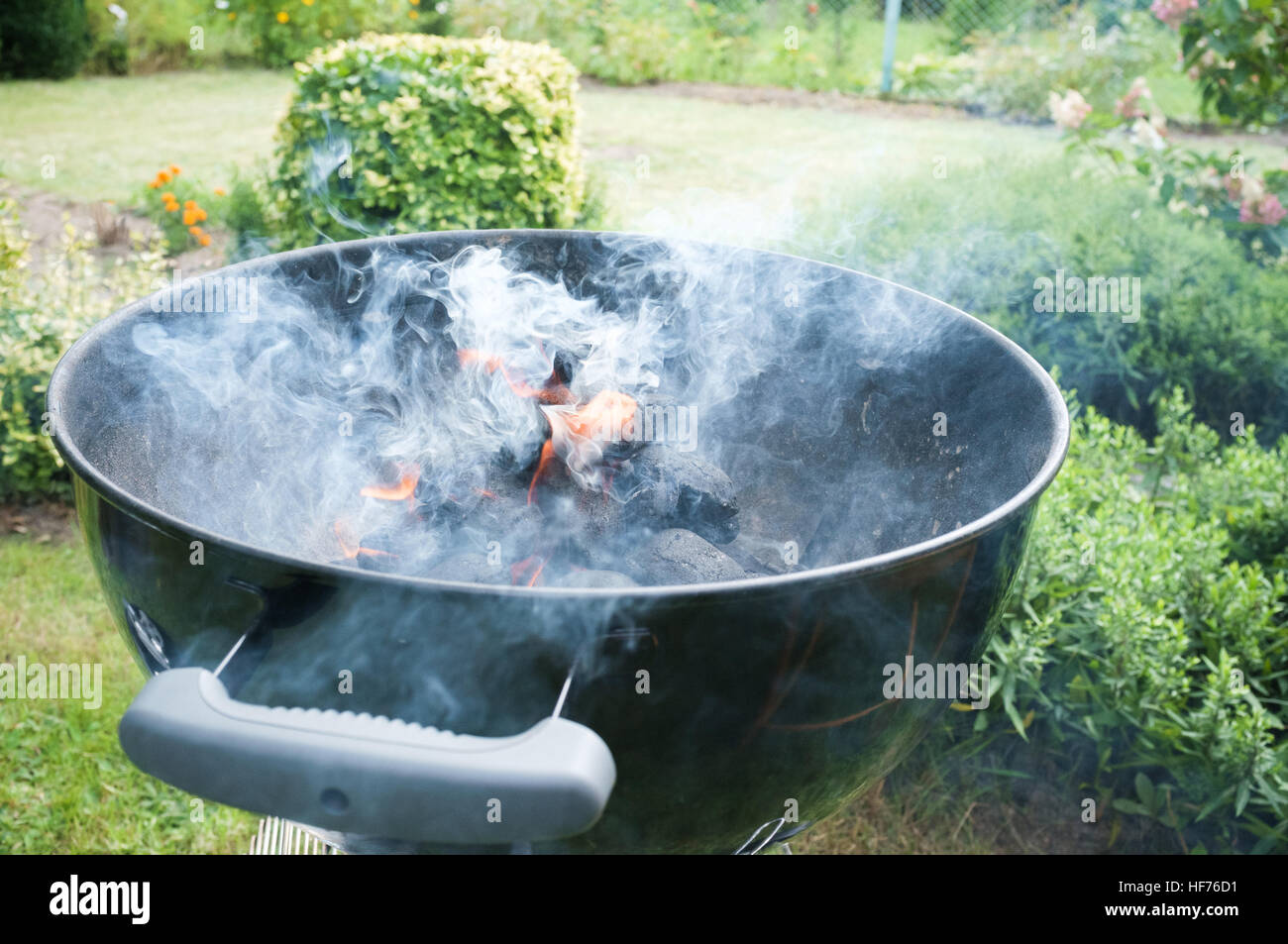 Smoke coming out of grill in backyard Stock Photo - Alamy